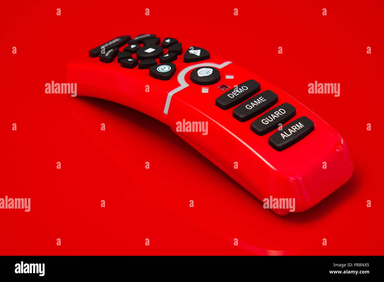 remote control of red shiny plastic with black rubber buttons, lying on ...