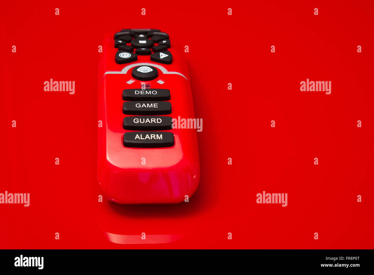 remote control for controlling a toy robot of red shiny plastic on a ...