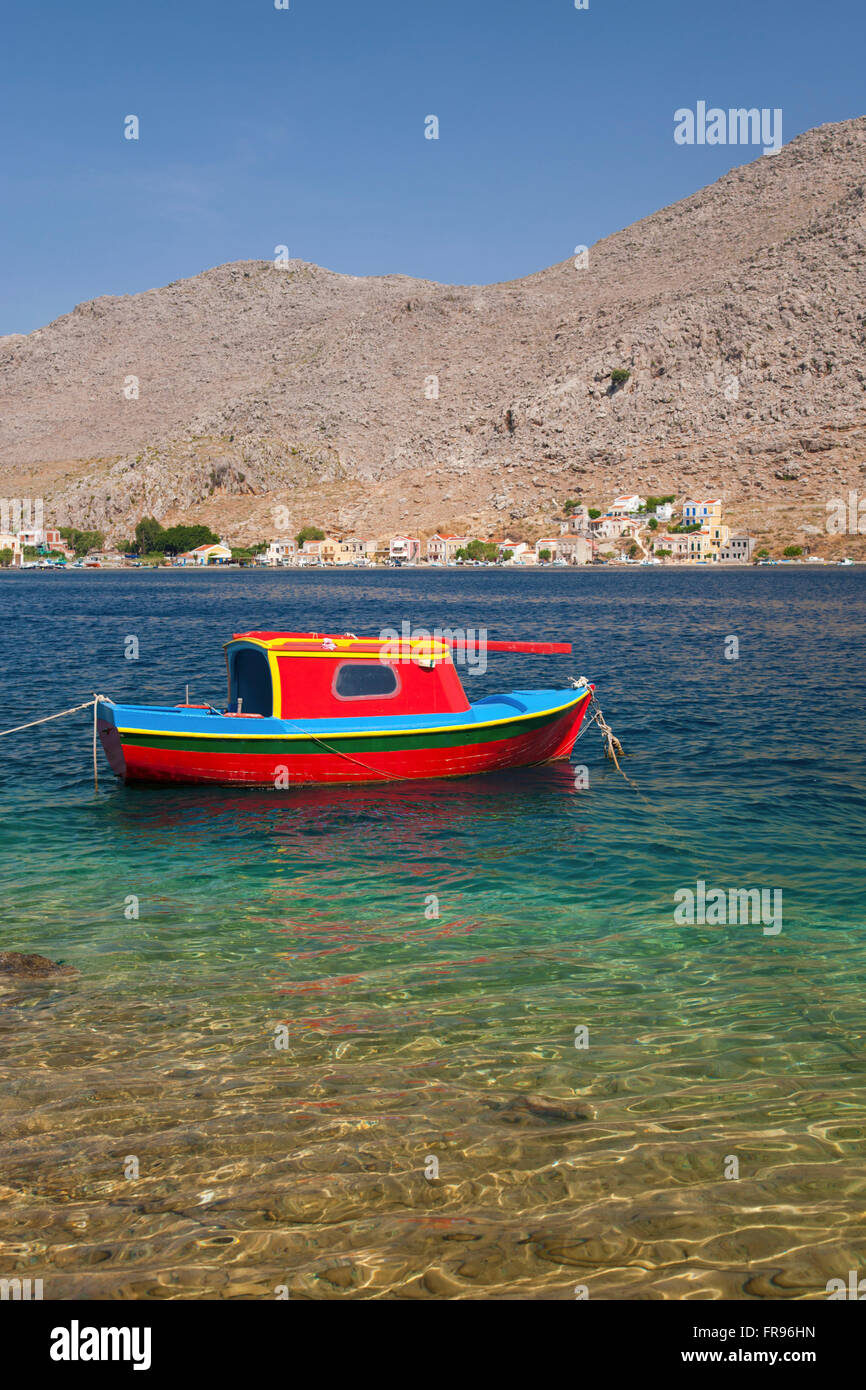 Pedi, Symi, South Aegean, Greece. Colourful boat anchored in the clear ...