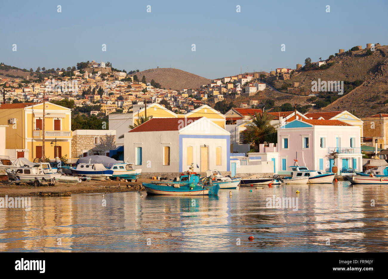 Pedi, Symi, South Aegean, Greece. Waterfront buildings lit by the ...