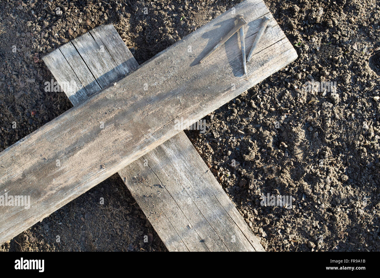 Wooden Cross laying on the ground with three nails nearby Stock Photo ...