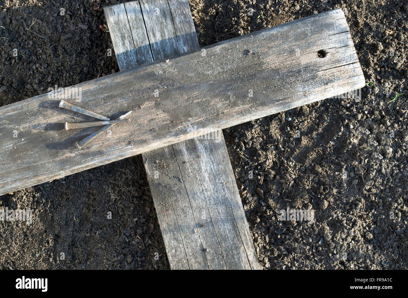 Wooden Cross laying on the ground with three nails nearby Stock Photo ...