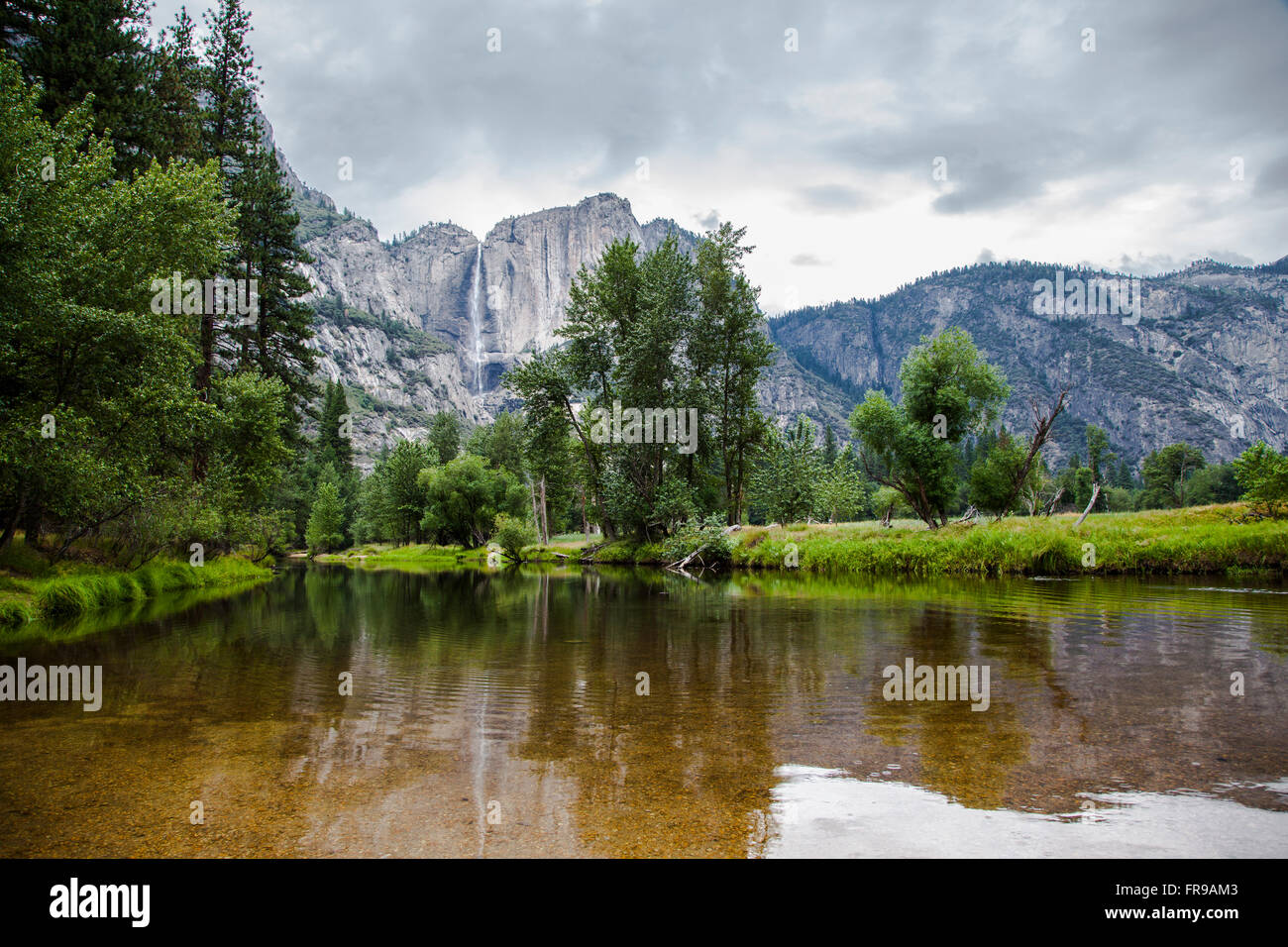Merced river in Yosemite valley with mountains and waterfall on ...