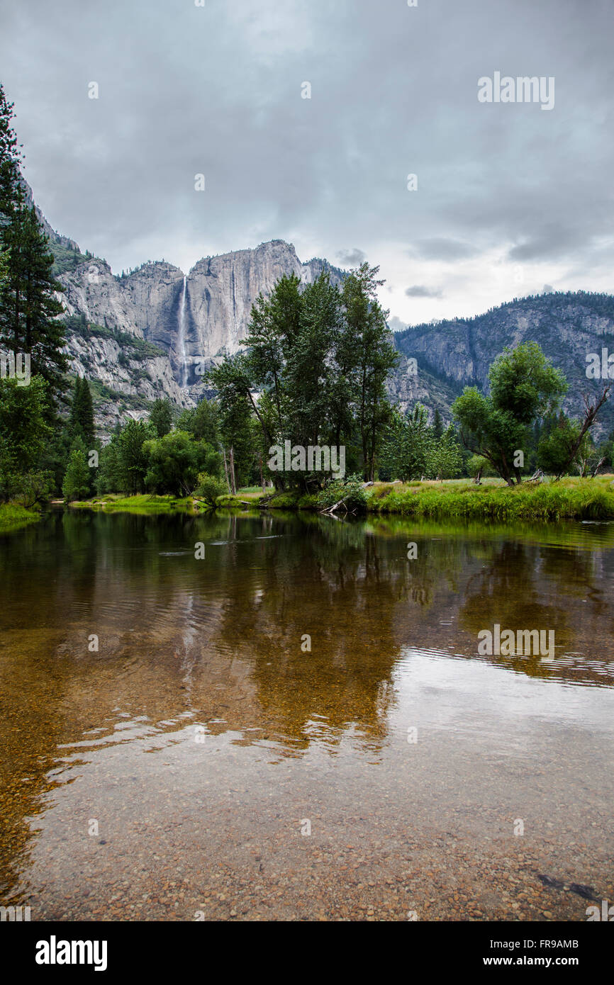 Merced river in Yosemite valley with mountains and waterfall on ...