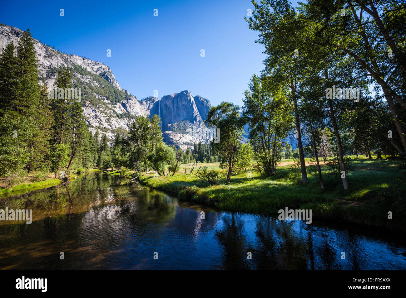 Merced river in Yosemite valley with mountains and waterfall on ...