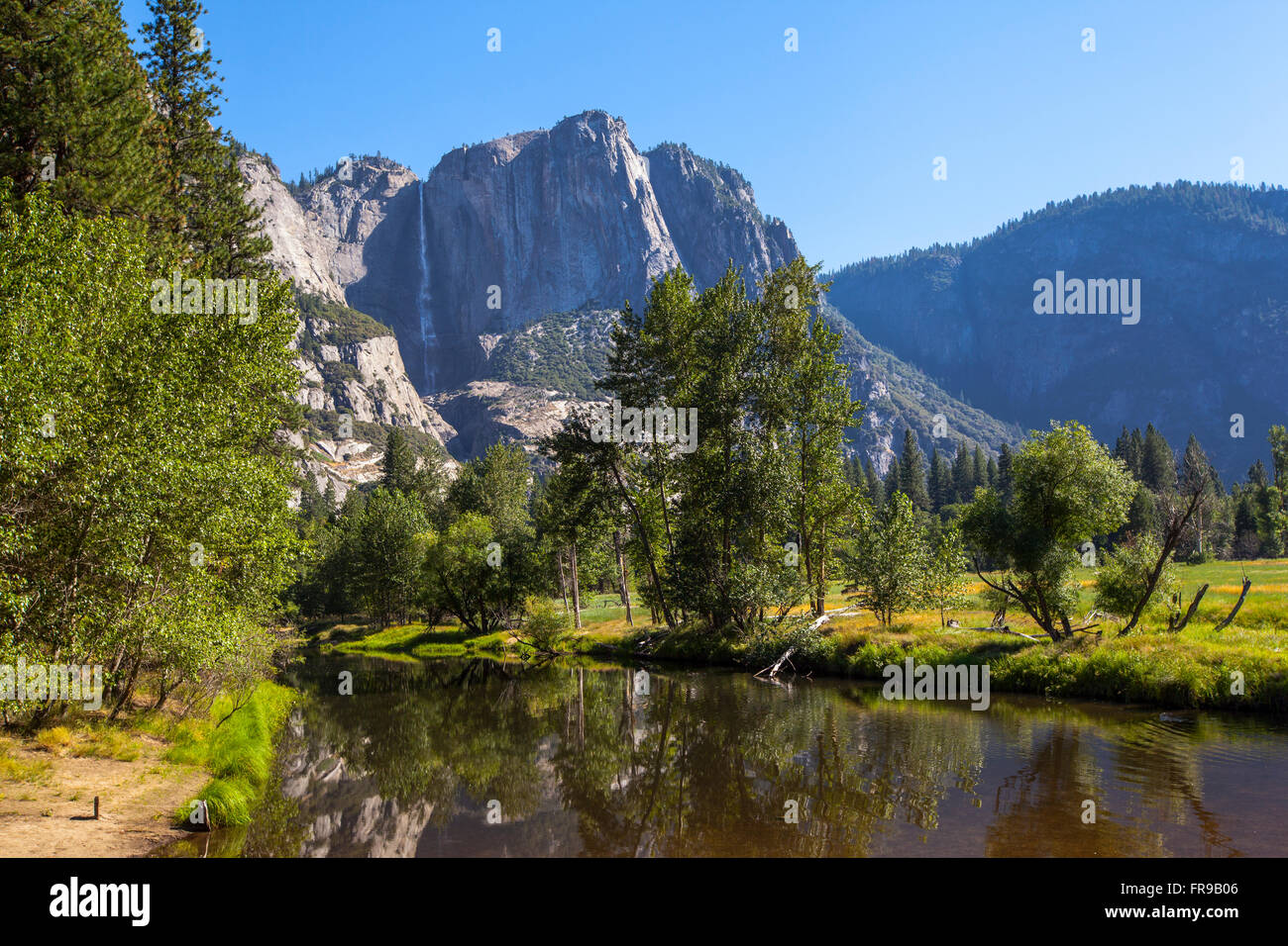 Merced river in Yosemite valley with mountains and waterfall on ...