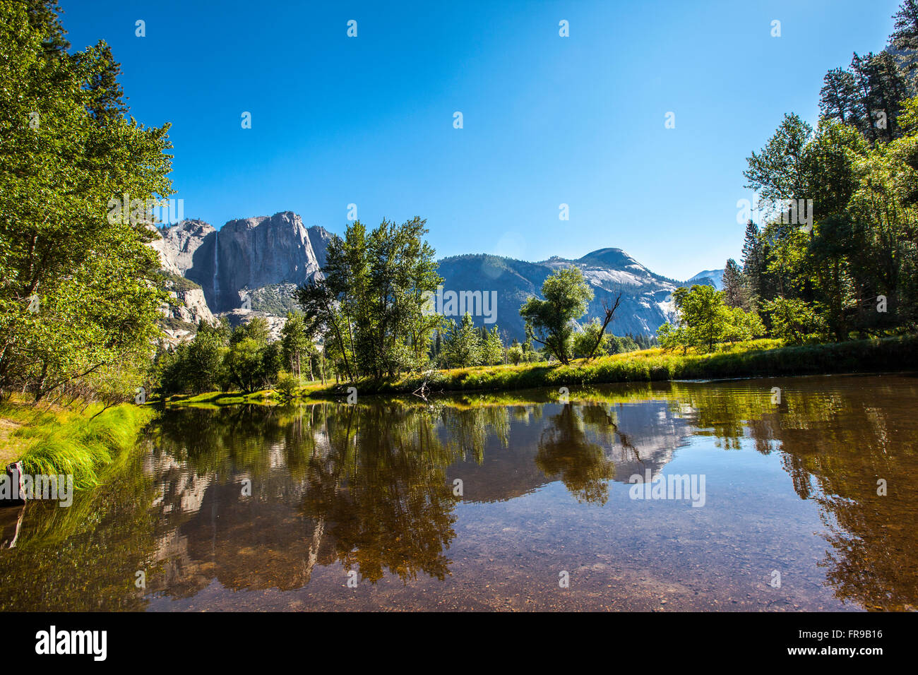 Merced river in Yosemite valley with mountains and waterfall on ...