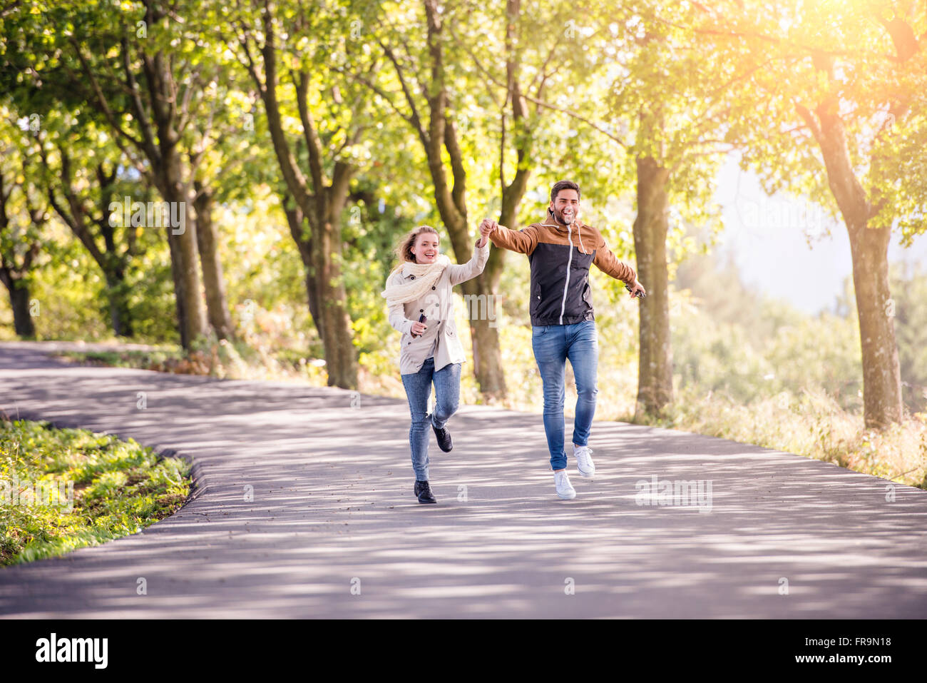 Couple in love in park on a walk, running Stock Photo - Alamy
