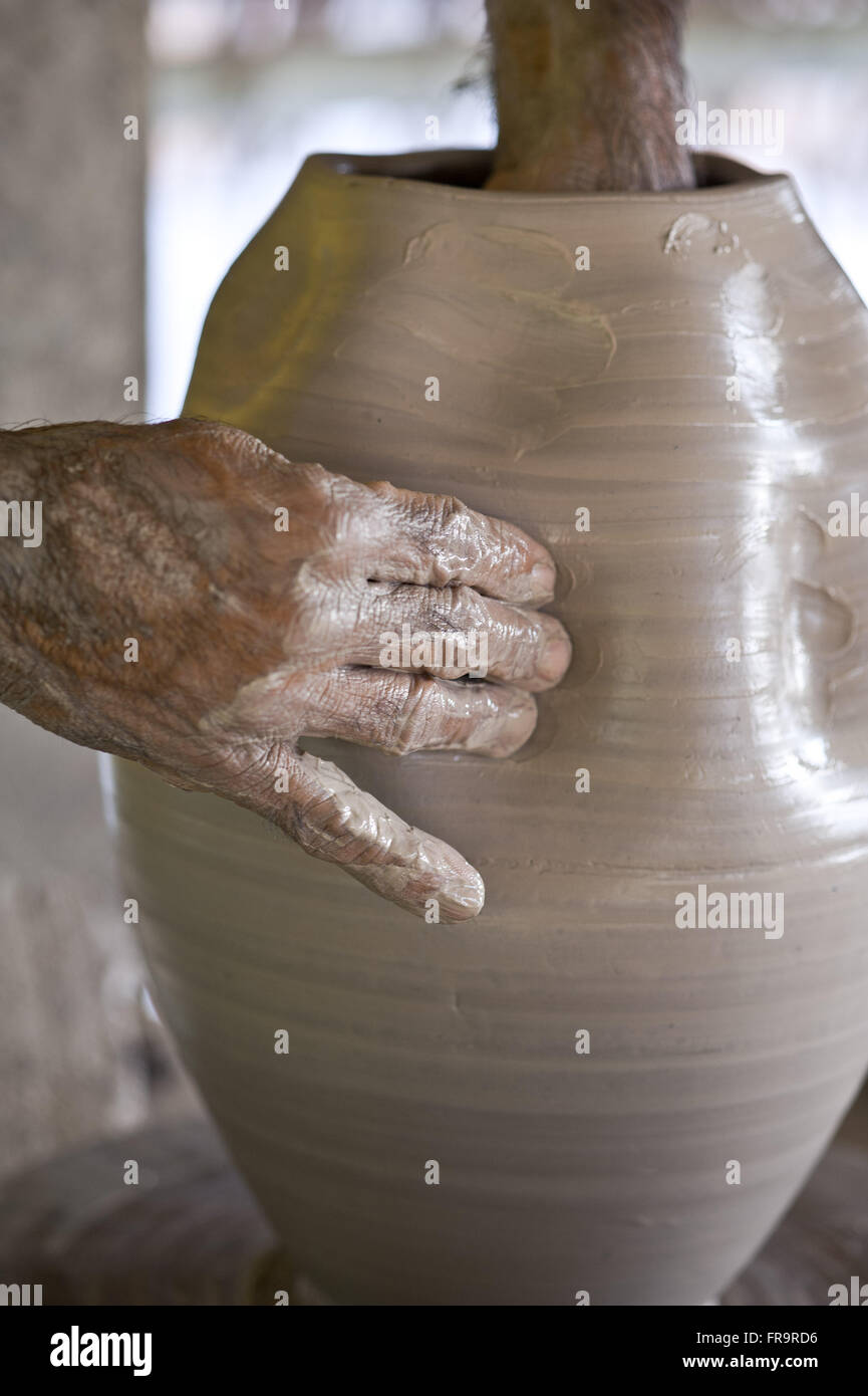 Potter shaping clay vessel with the aid of a lathe Stock Photo - Alamy