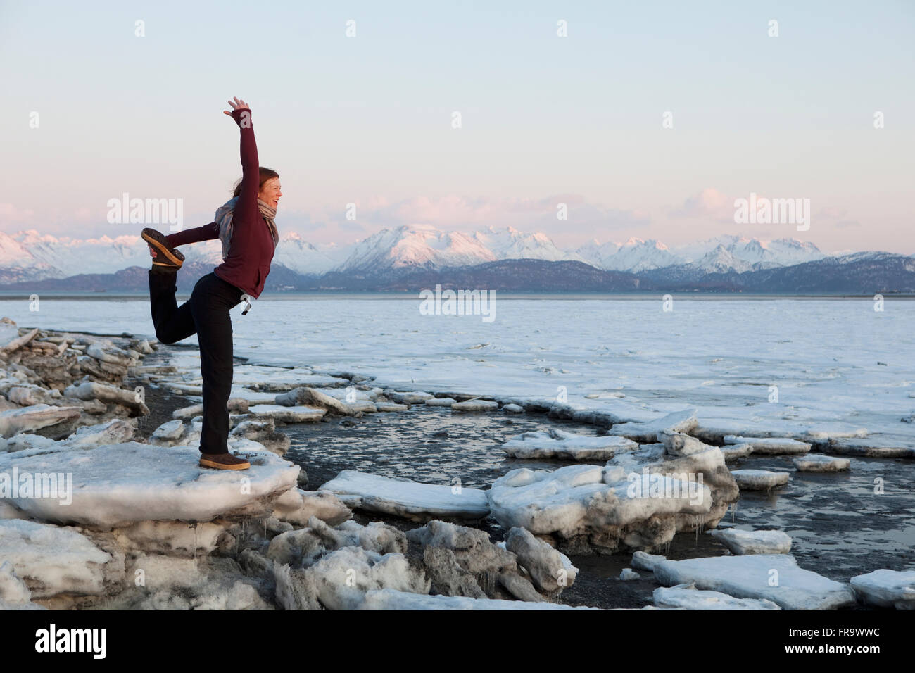 Woman practices yoga on an ice chunk on a beach in Homer, Southcentral ...