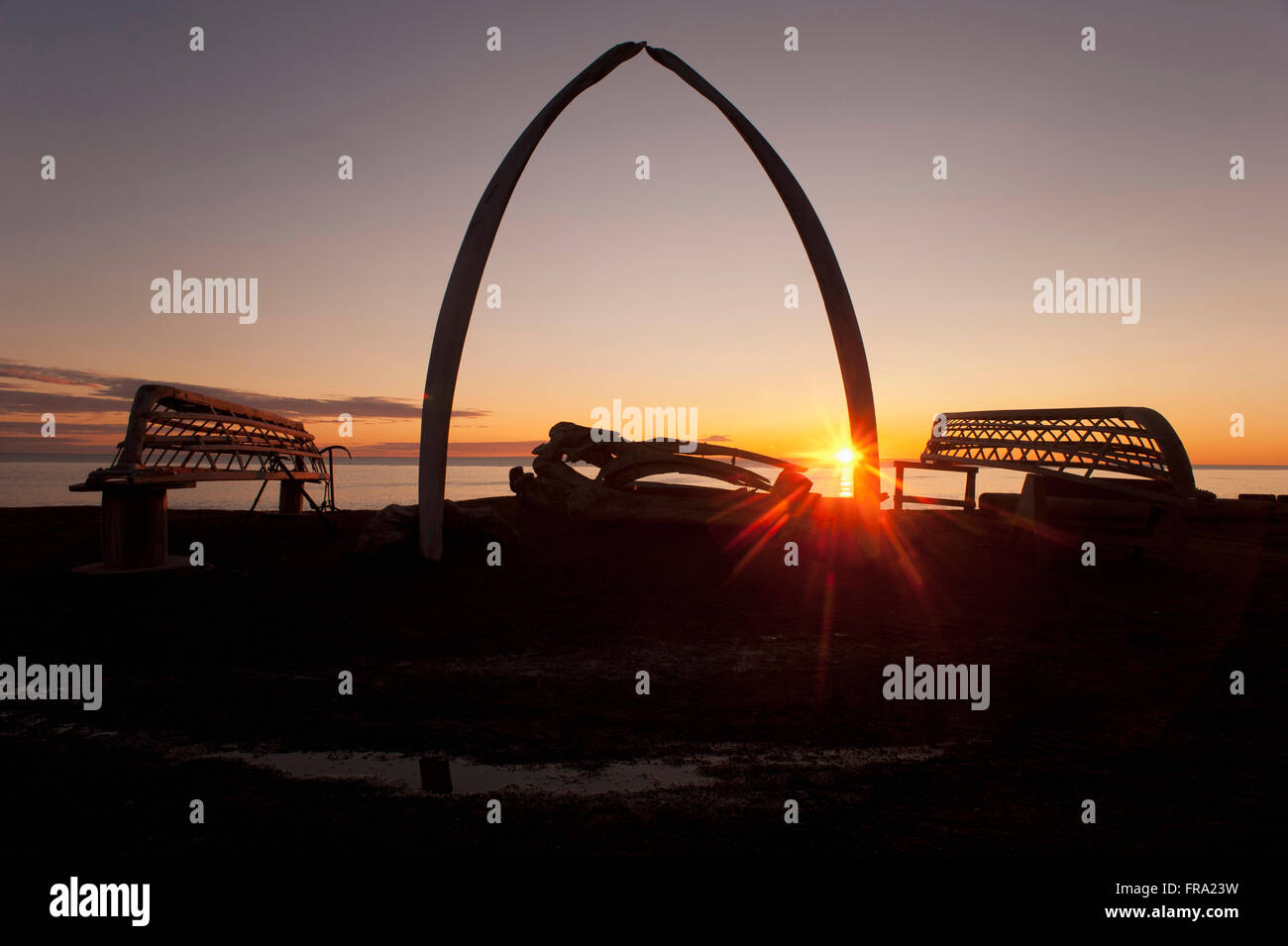 Iconic bowhead whale bone arch and wooden whaling boat at sunset on the ...
