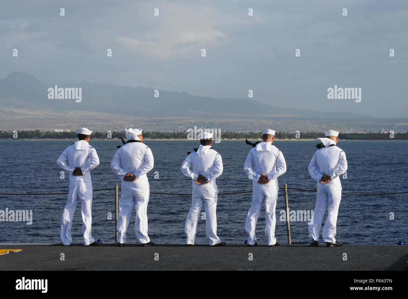 Sailors "man the rails" in dress whites as the ship comes into Pearl ...