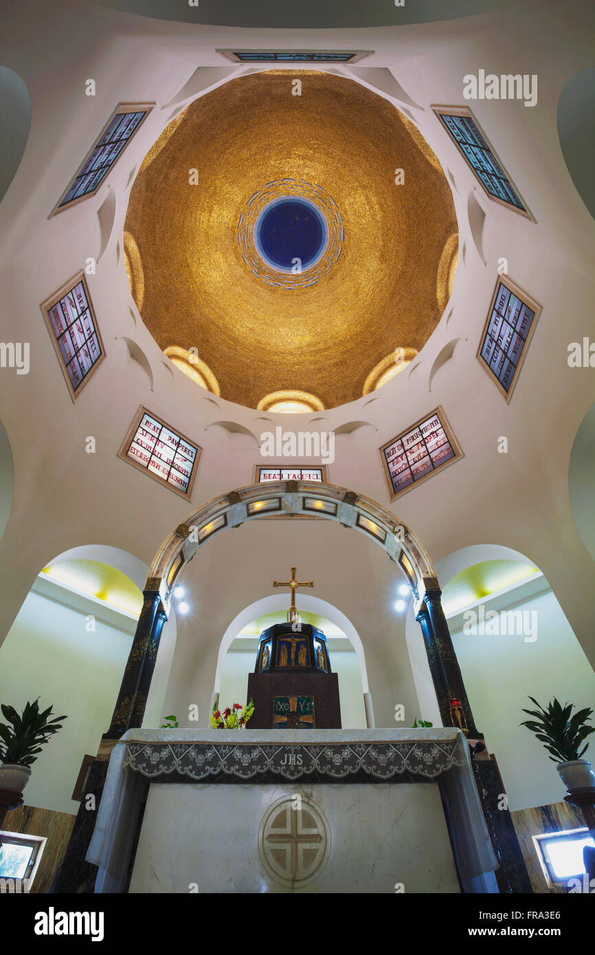 Interior of a church with stained glass windows and a gold domed ...
