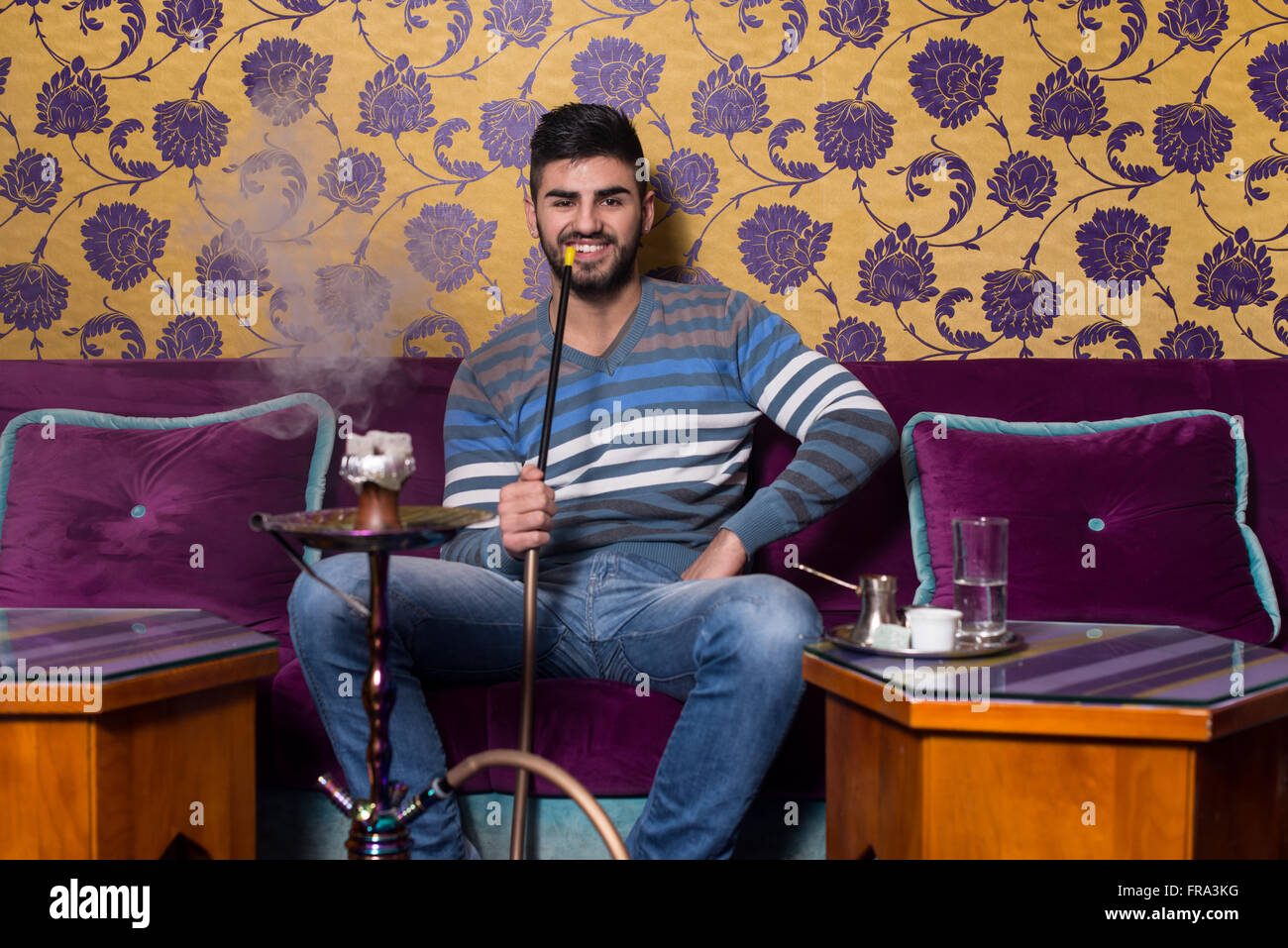 Man Smoking Turkish Hookah In The Cafe With Colorful Walls On ...