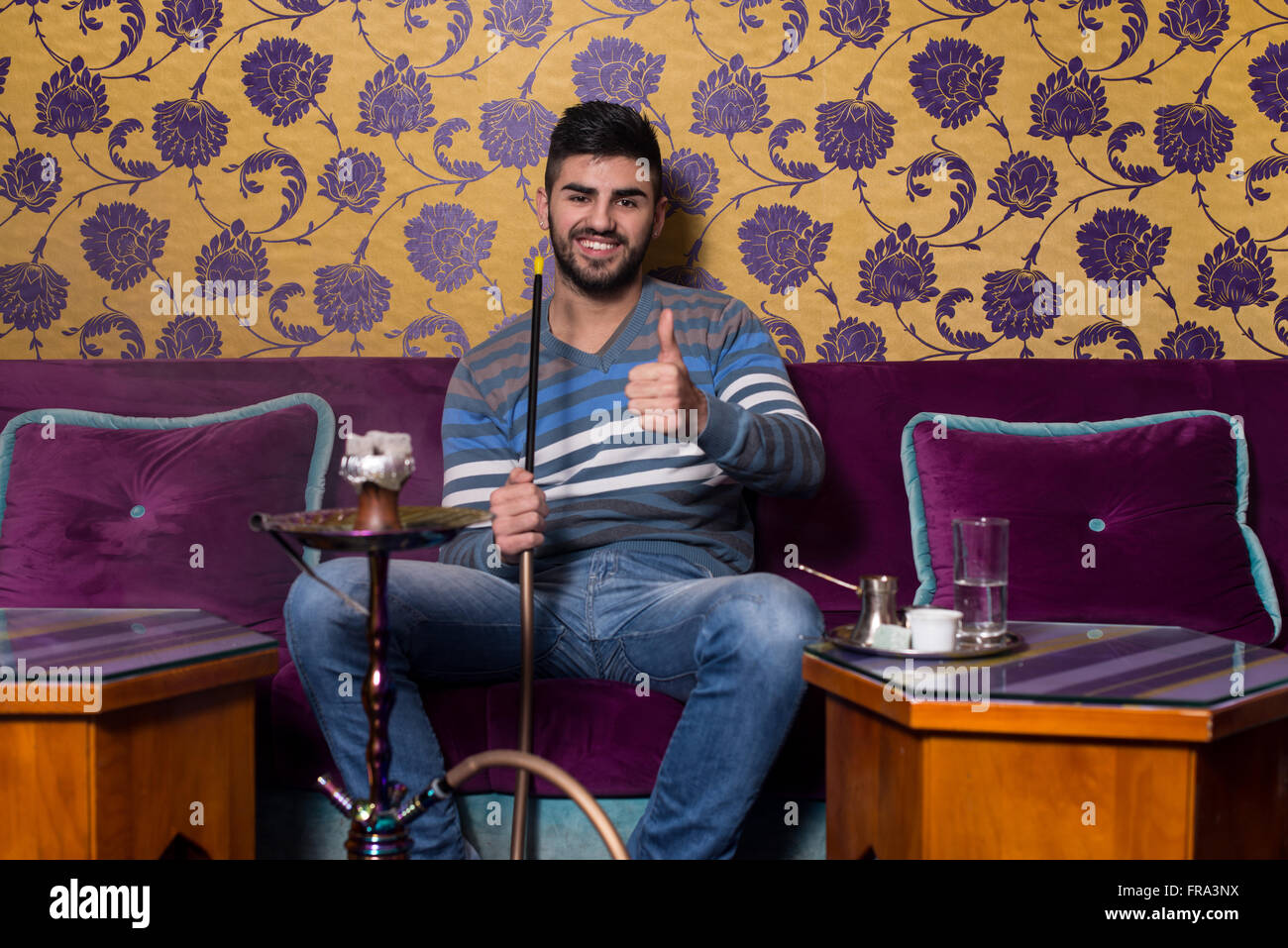 Young Man Smoking Shisha At Arabic Restaurant - Man Exhaling Smoke ...