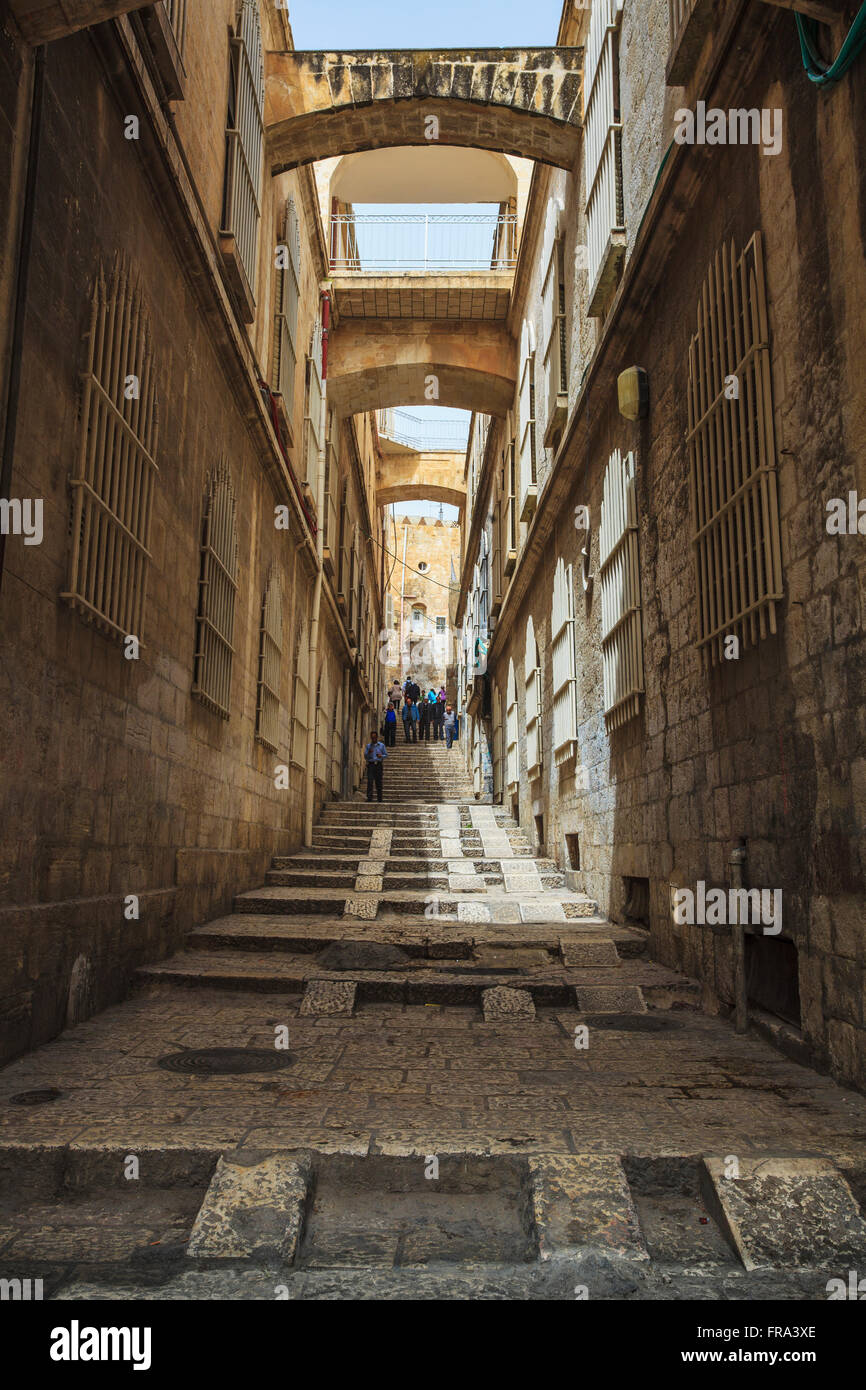 Steps on a walkway in-between buildings with a view of a blue sky ...