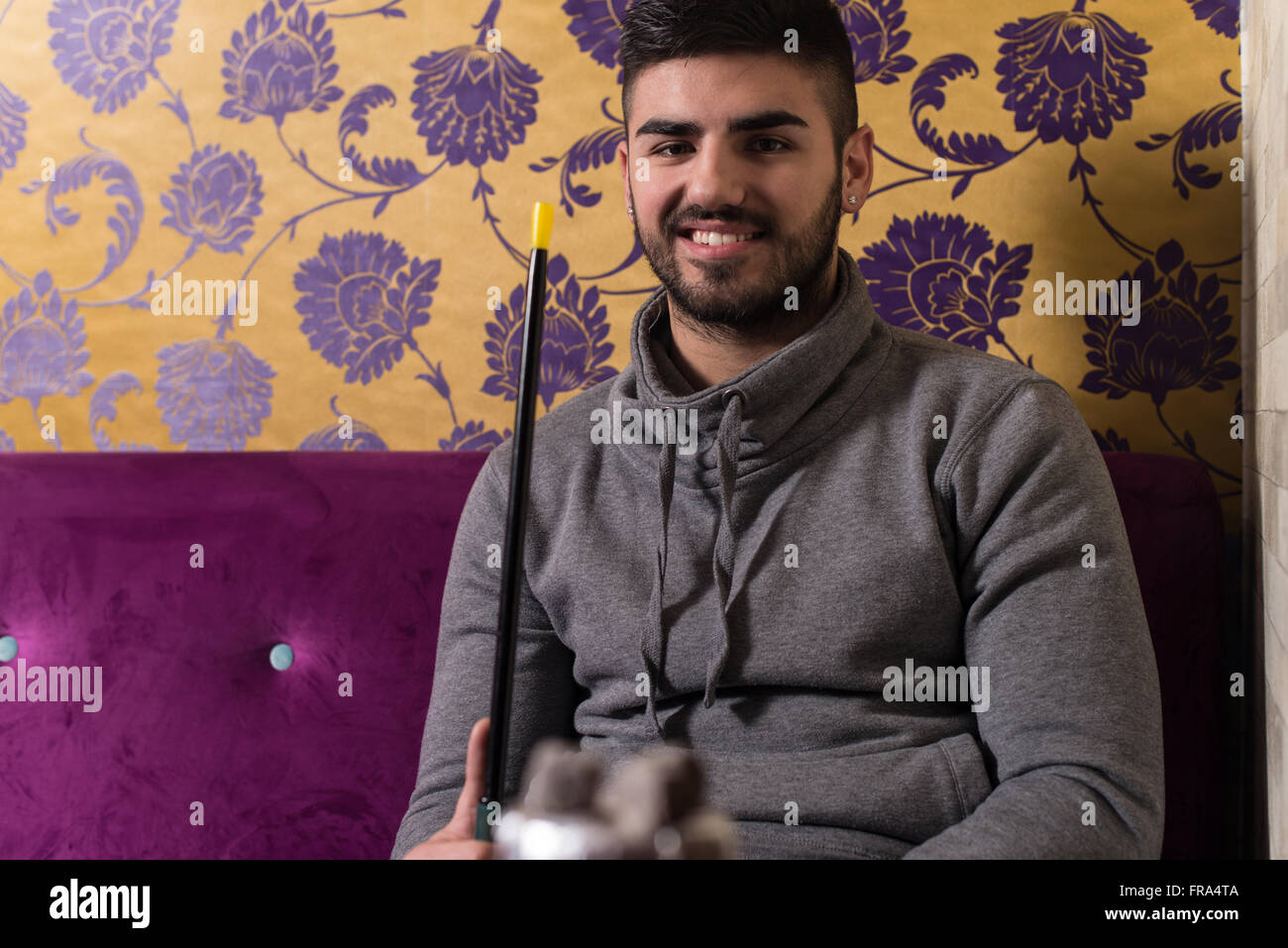 Young Man Smoking Shisha At Arabic Restaurant - Man Exhaling Smoke ...