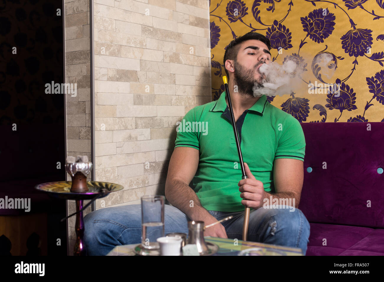 Man Smoking Turkish Hookah In The Cafe With Colorful Walls On ...
