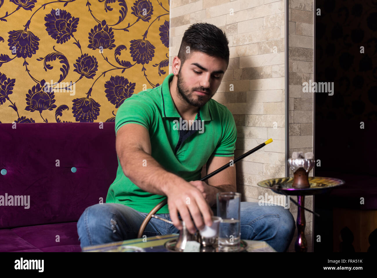 Young Man Smoking Shisha At Arabic Restaurant - Man Exhaling Smoke ...