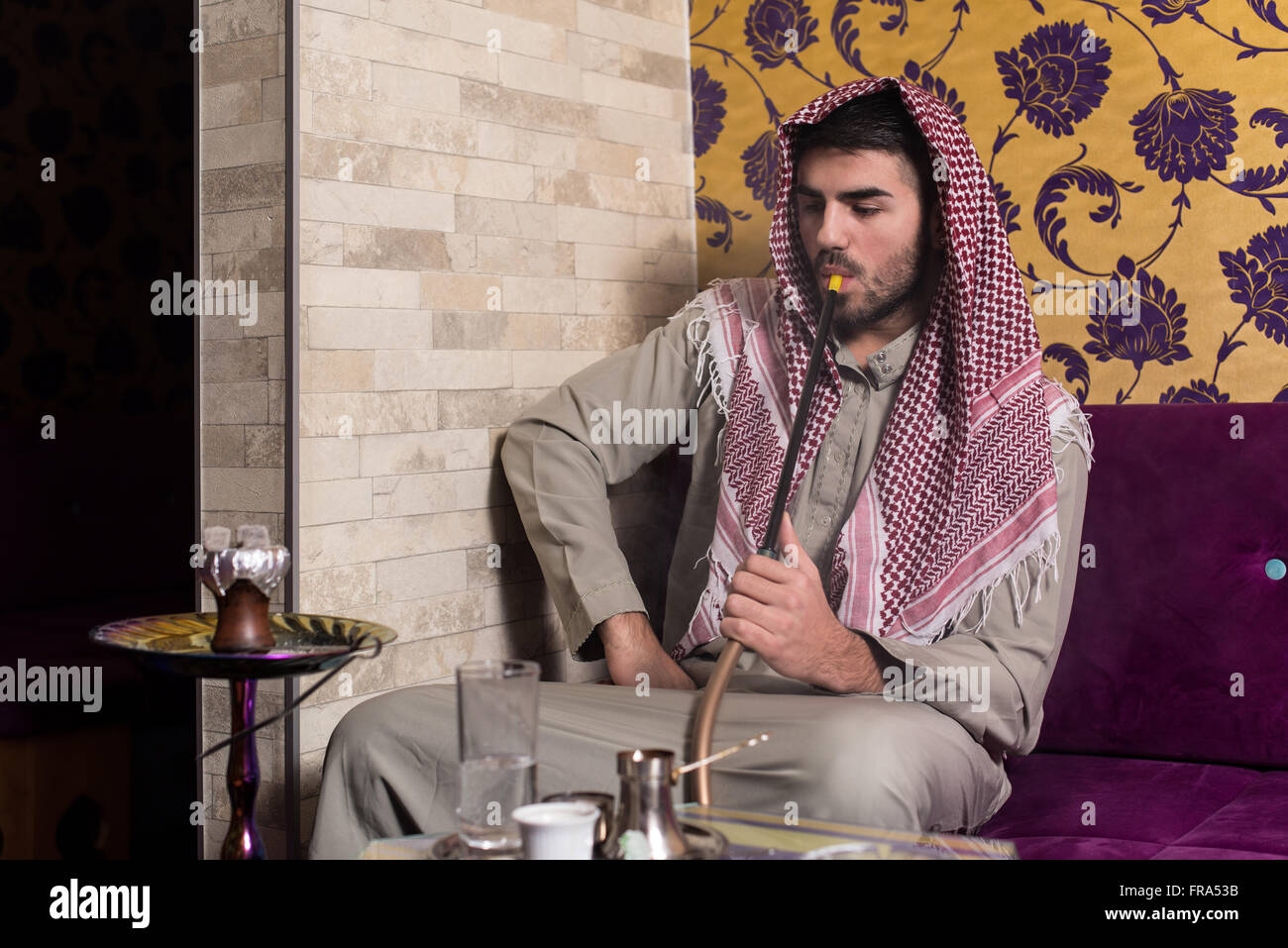 Islamic Man Smoking The Traditional Hubble-Bubble Or Hookah While ...