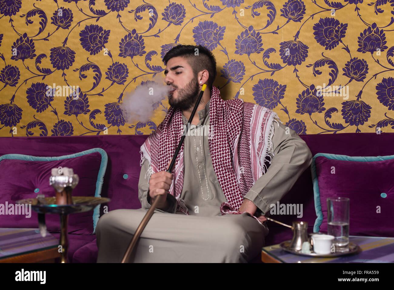 Muslim Man Smoking Shisha At Arabic Restaurant Exhaling Smoke Stock
