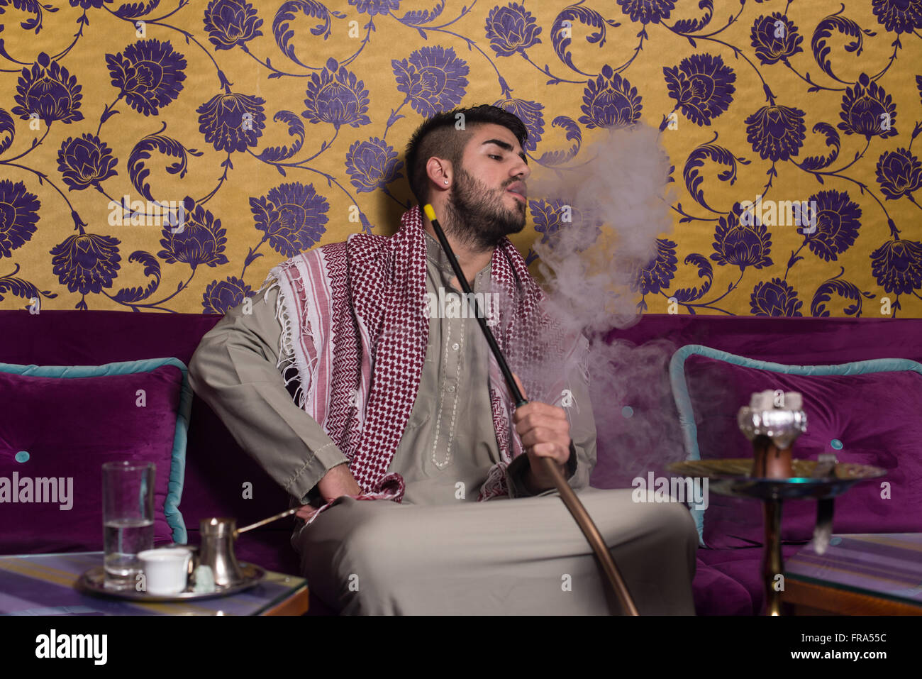 Muslim Man Smoking Turkish Hookah In The Cafe With Colorful Walls On ...