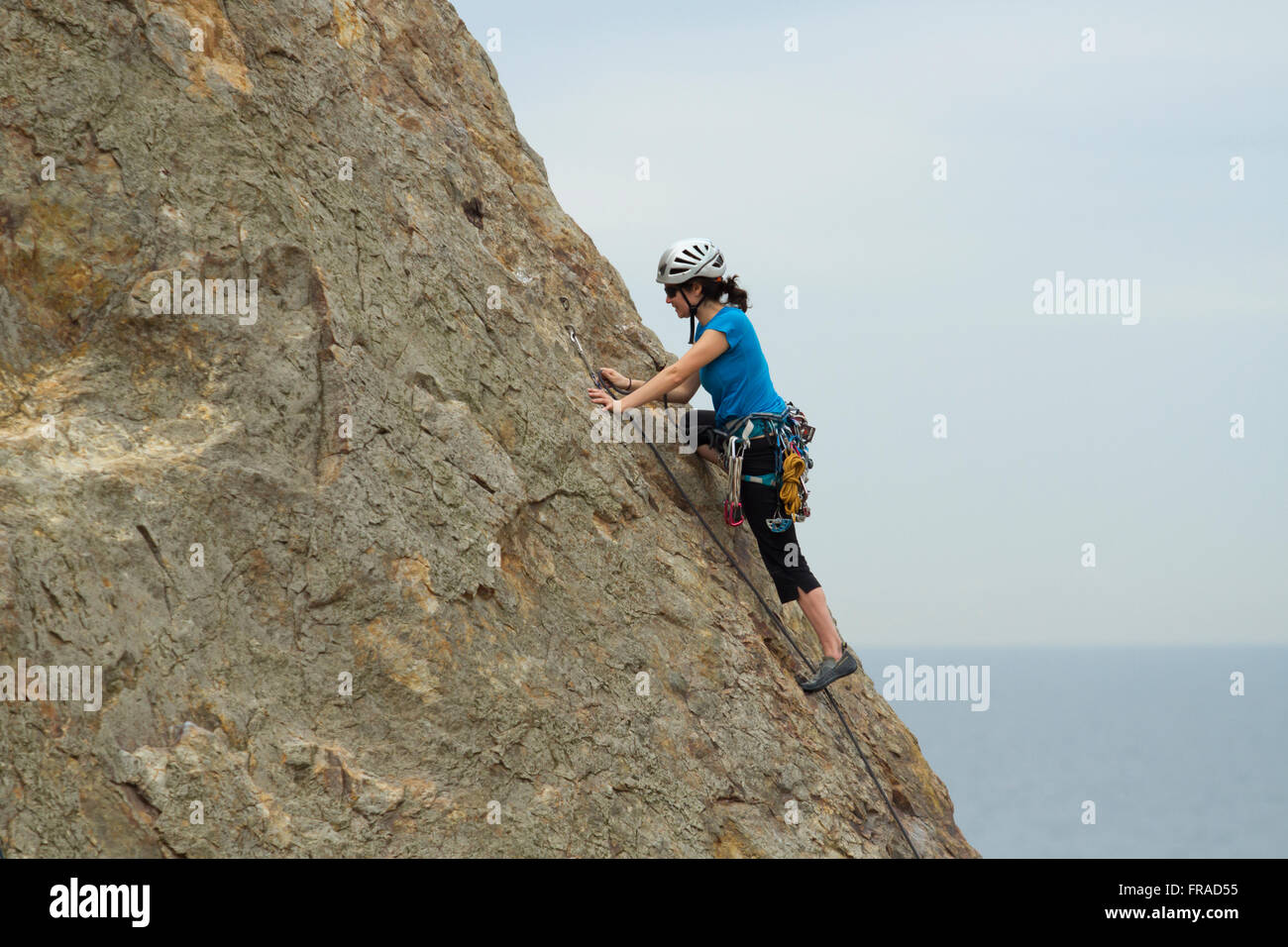 Woman rock climbing up cliff hi-res stock photography and images - Alamy