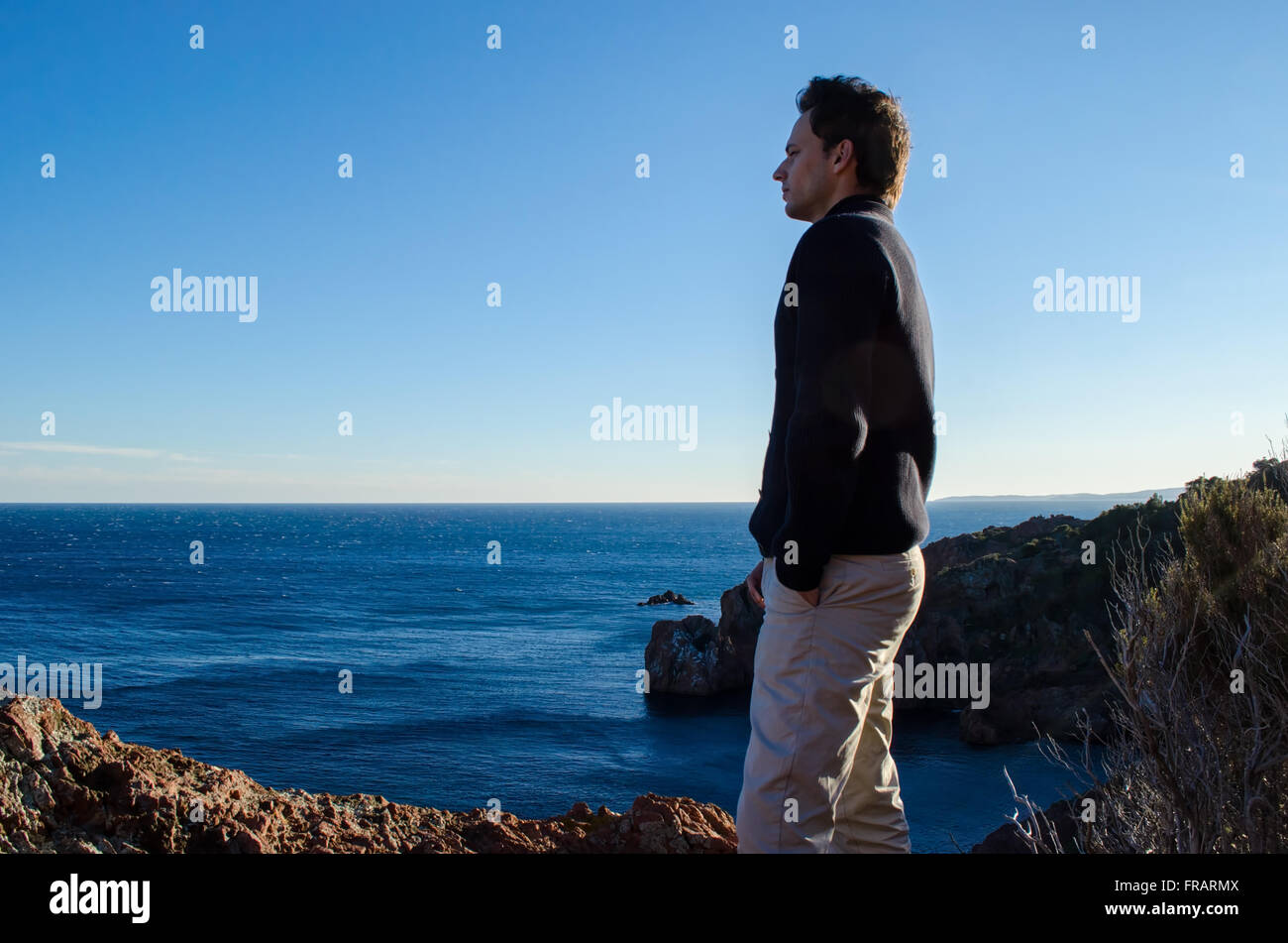 A man standing and looking at the horizon Stock Photo - Alamy