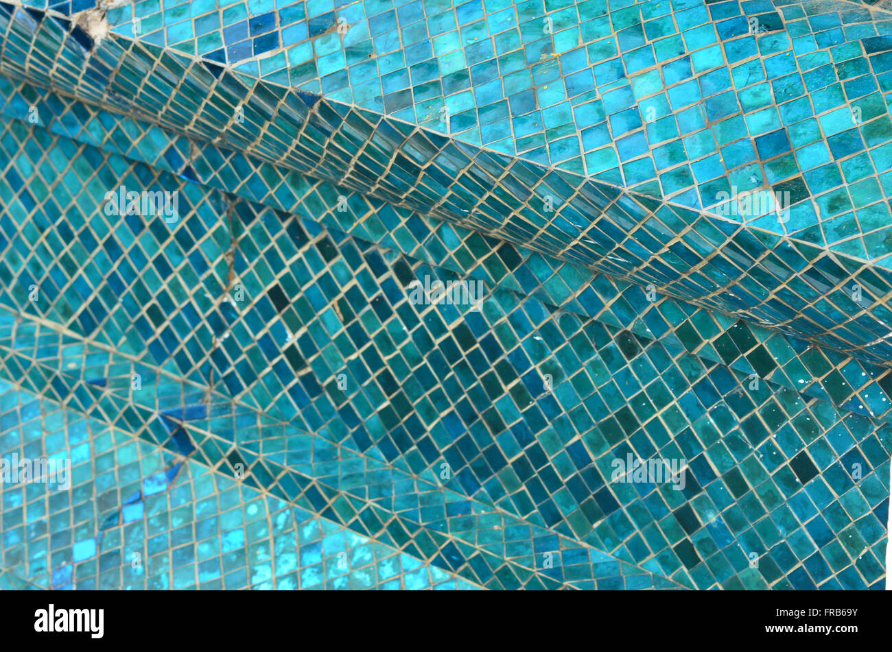 An abstract of blue, diamond-shaped tiles. They form a step. Between ...