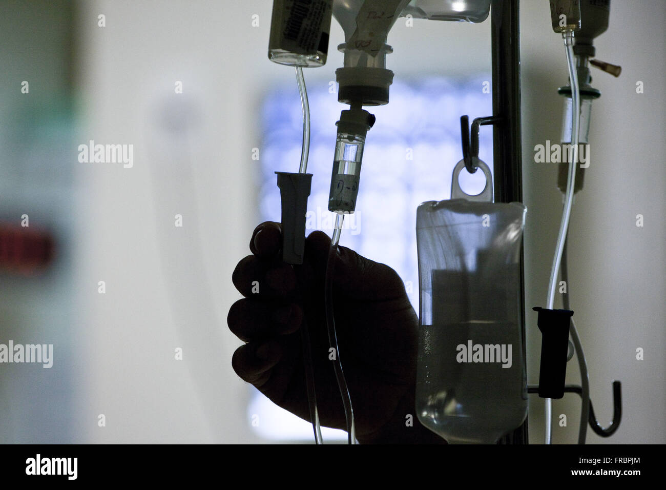 Detail of the hand of nurse watching serum applied tube inpatient ICU ...