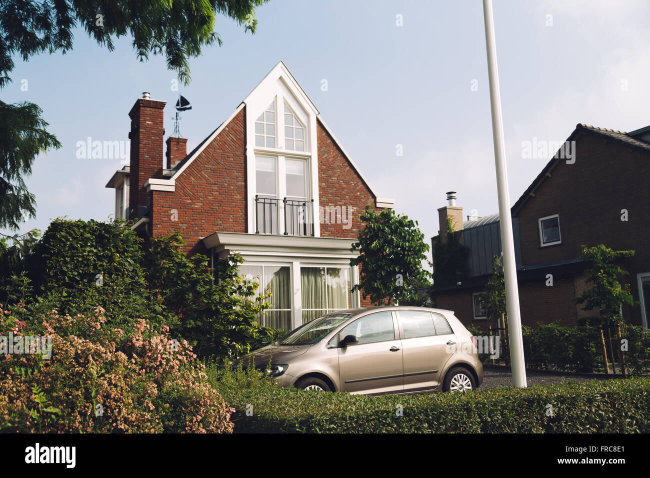car parked outside the house in bushes Stock Photo - Alamy