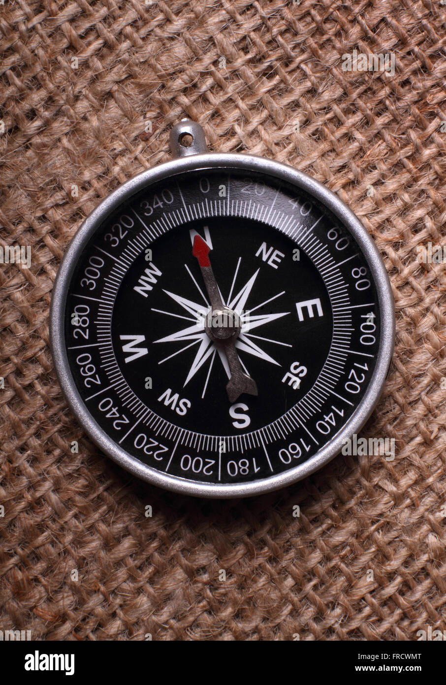 Antique compass pointing North on a rustic burlap background Stock ...