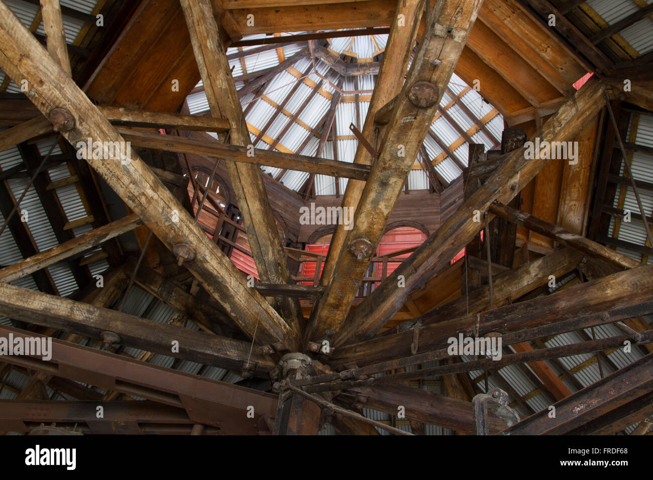 Aged and worn wooden rafters with rusting metal girders inside decaying ...