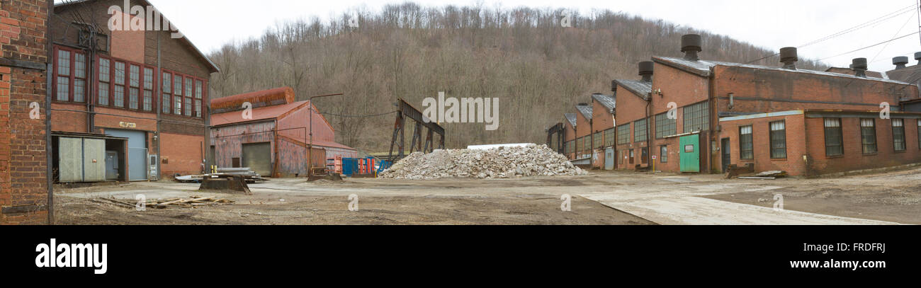 Outside of brick buildings of abandoned steel mill with rusting ...