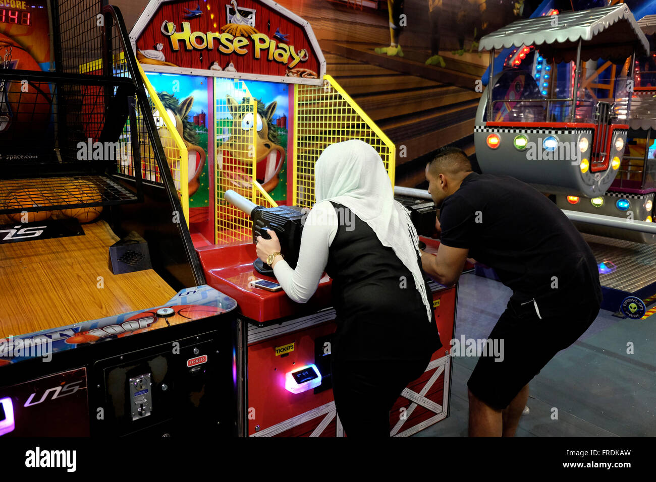 An Israeli Arab couple playing a machine gun game at the Ice Shopping ...