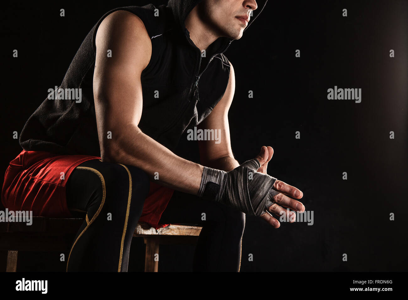 The muscular man sitting and resting on black Stock Photo - Alamy