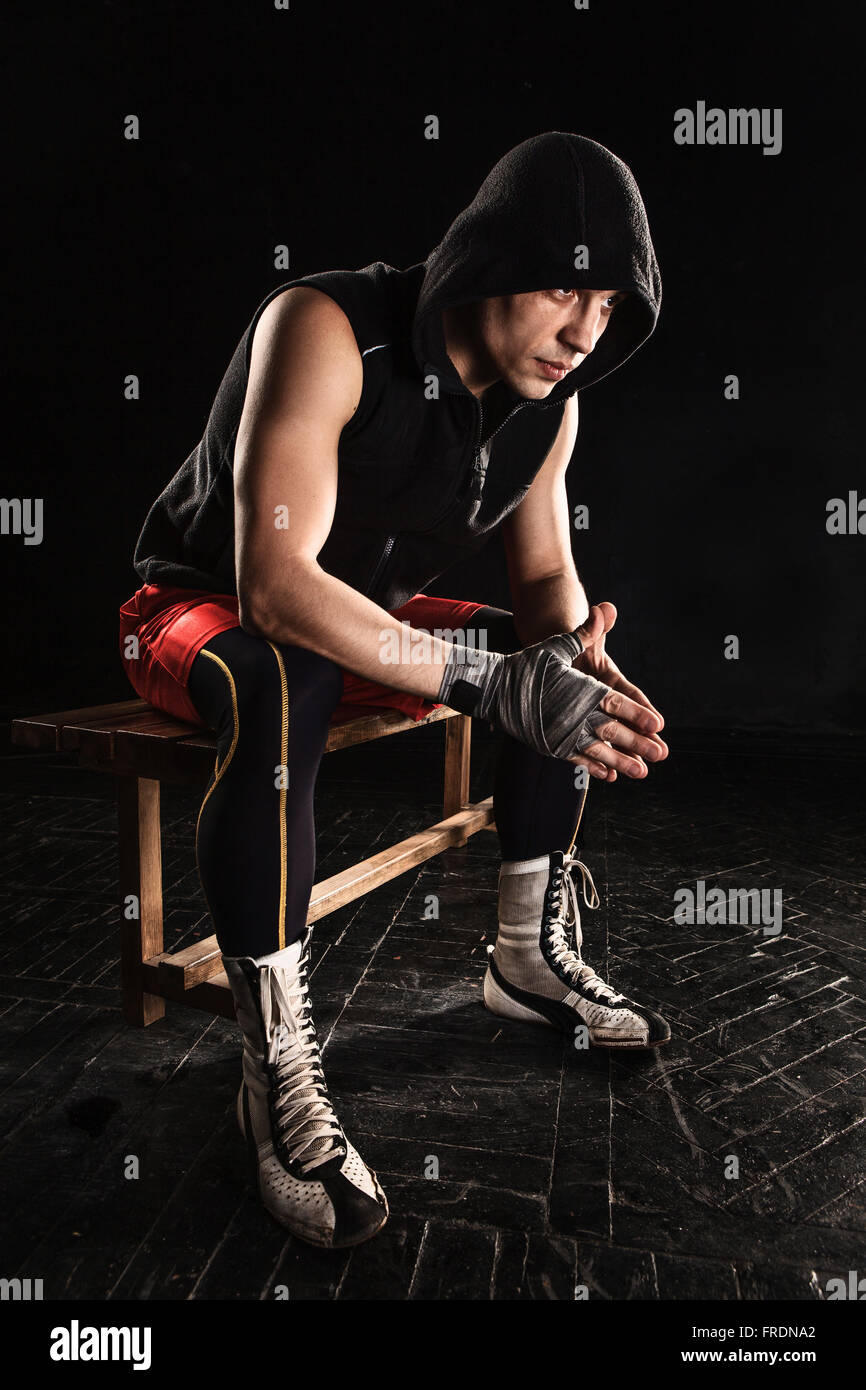 The muscular man sitting and resting on black Stock Photo - Alamy