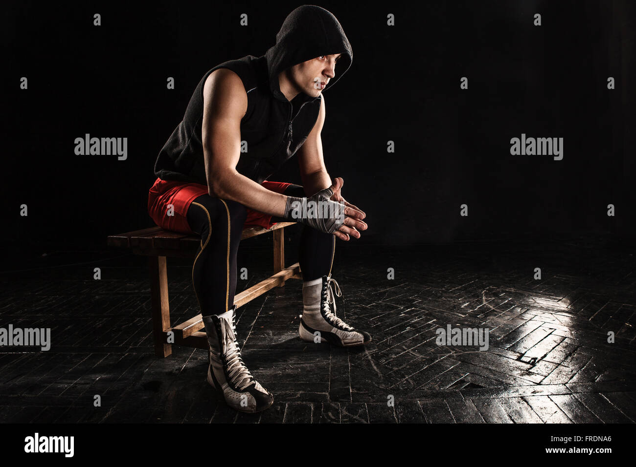 The muscular man sitting and resting on black Stock Photo - Alamy