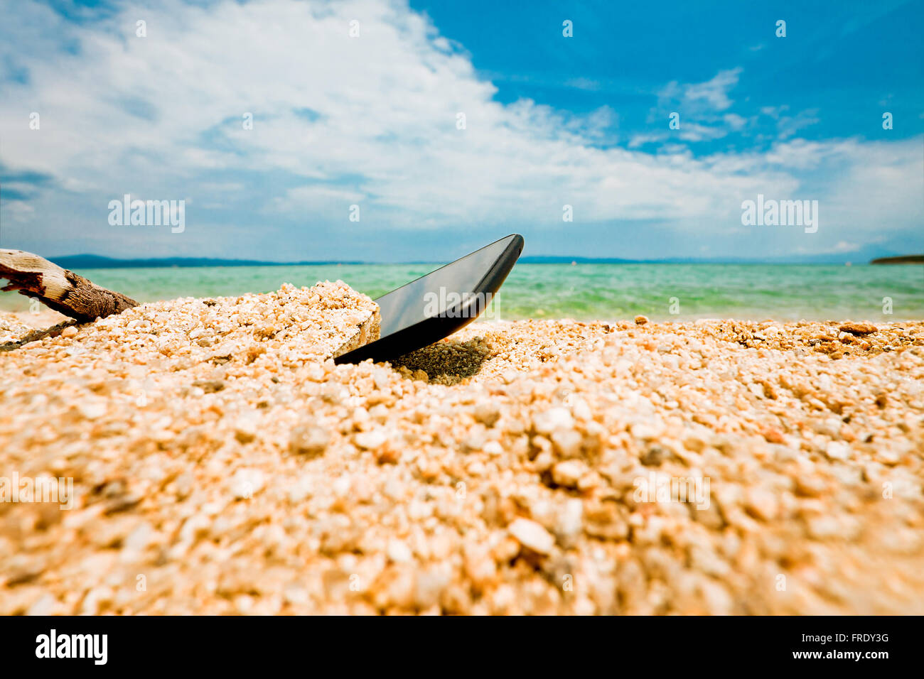 Thrown, half buried in the sand of an ocean or sea shore sand ...