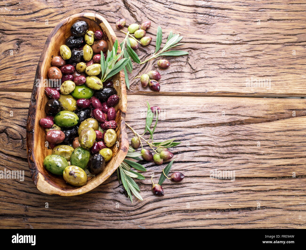 Whole table olives in the wooden bowl on the table Stock Photo - Alamy