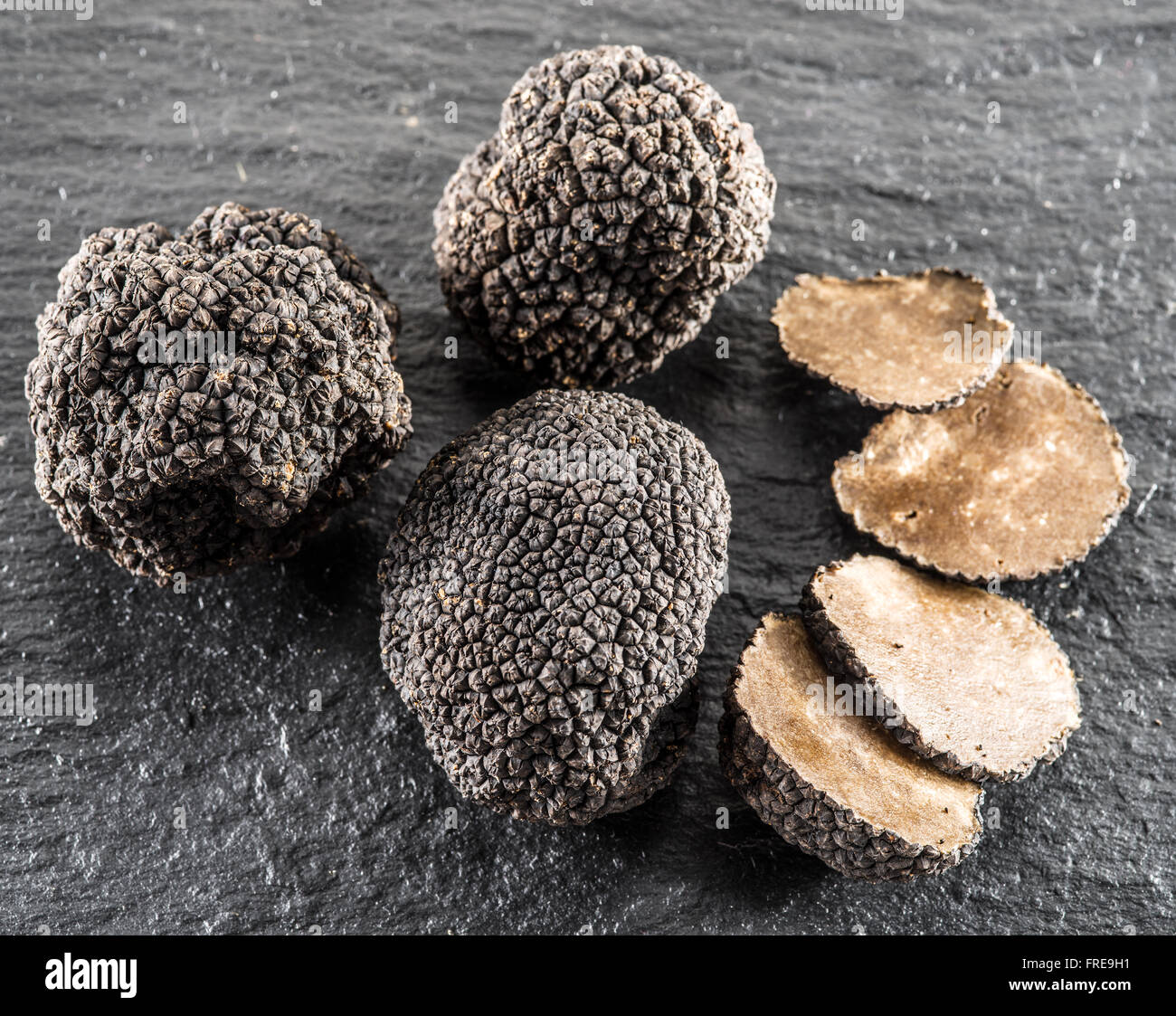 Black truffles and truffle slices on the graphite board Stock Photo - Alamy