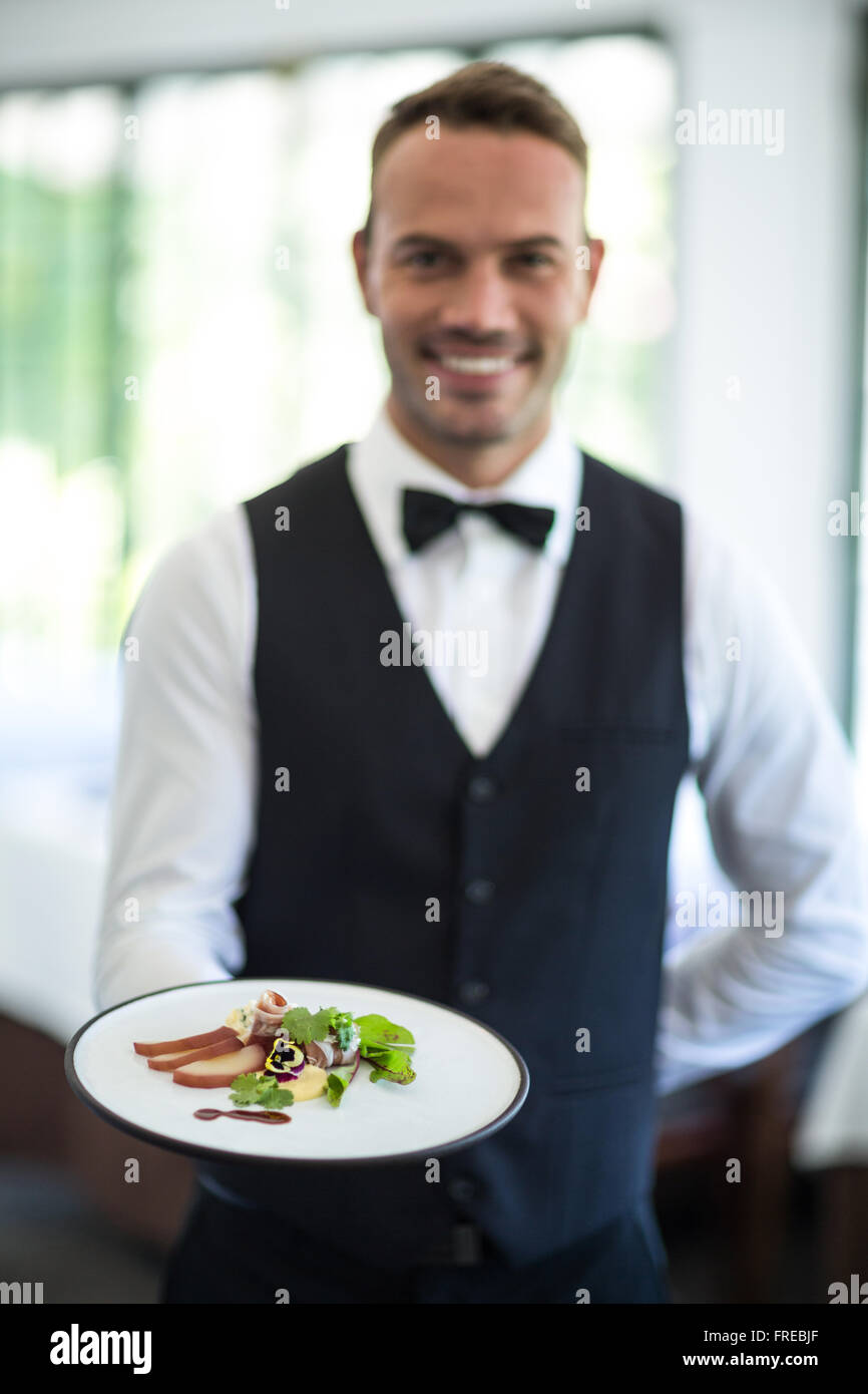 Waiter showing a dish Stock Photo - Alamy