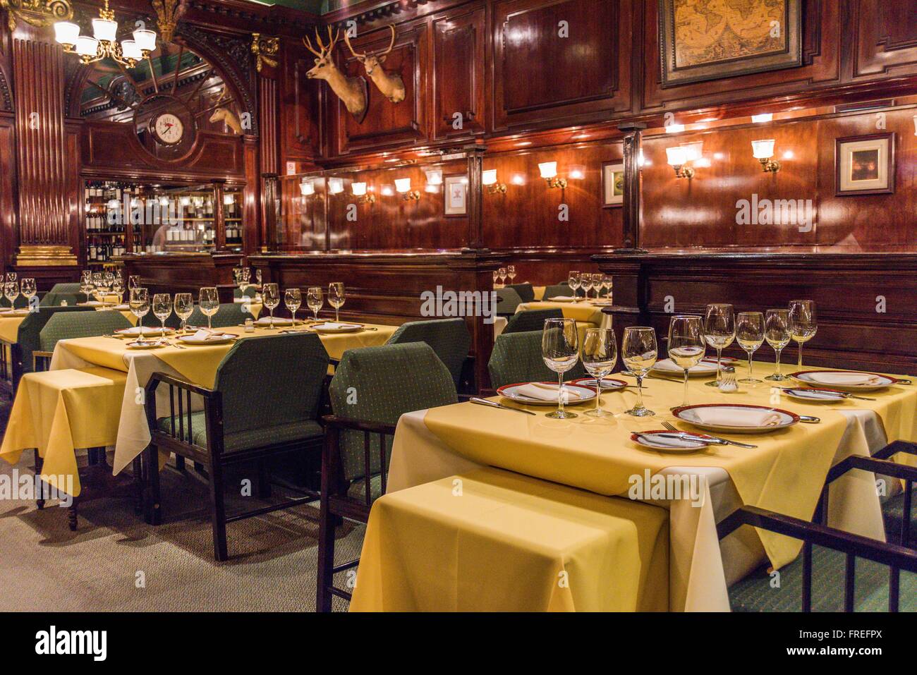 Tables laid for guests at wood-panelled restaurant Stock Photo - Alamy