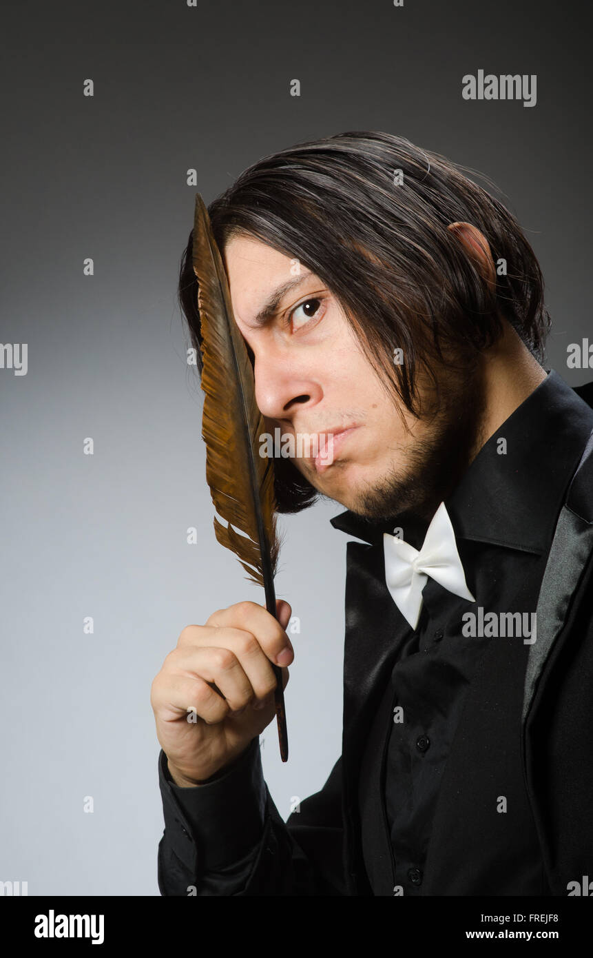 Young man with writing feather Stock Photo - Alamy