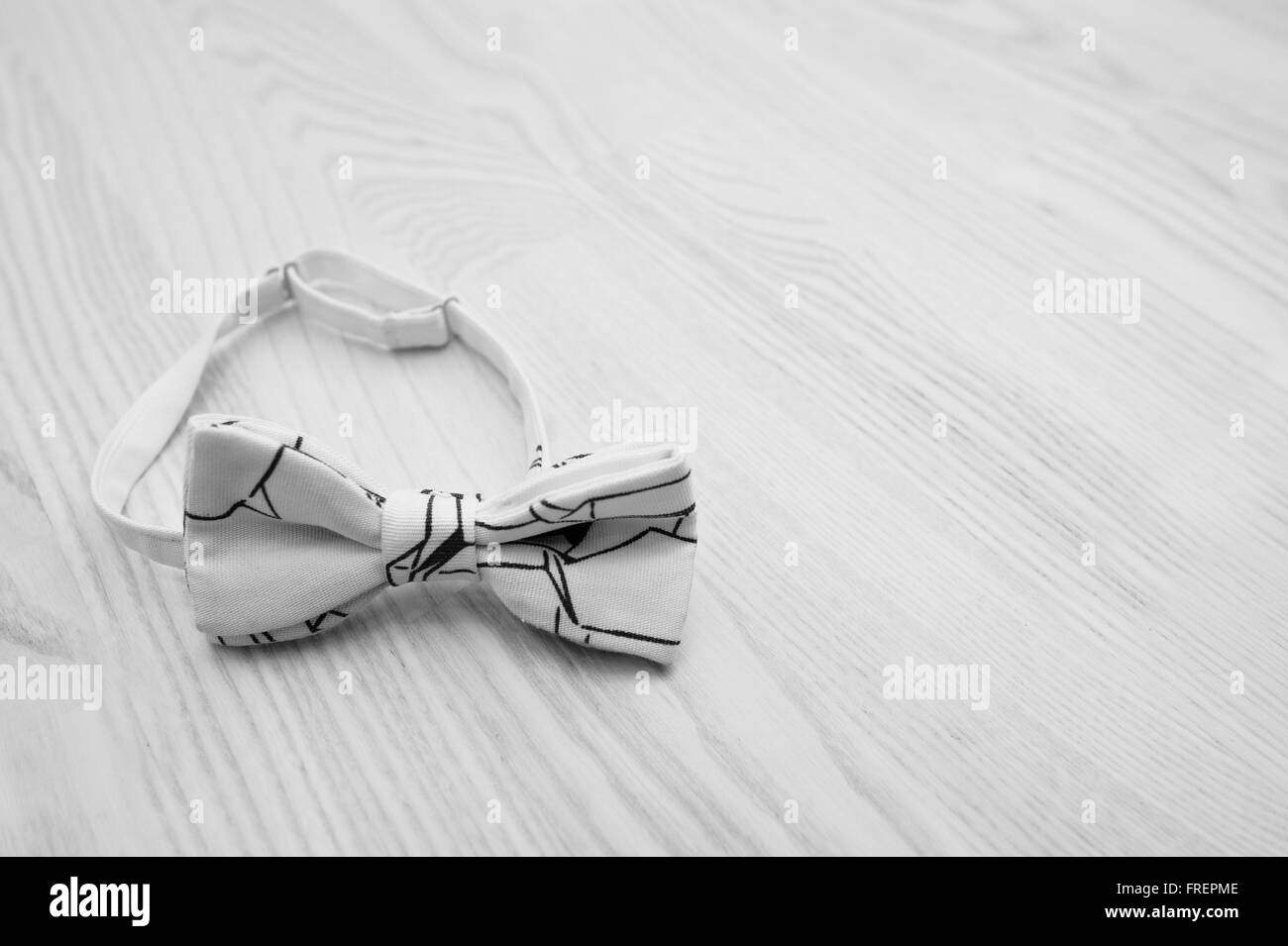 White hi tech bow tie on light wooden background Stock Photo - Alamy