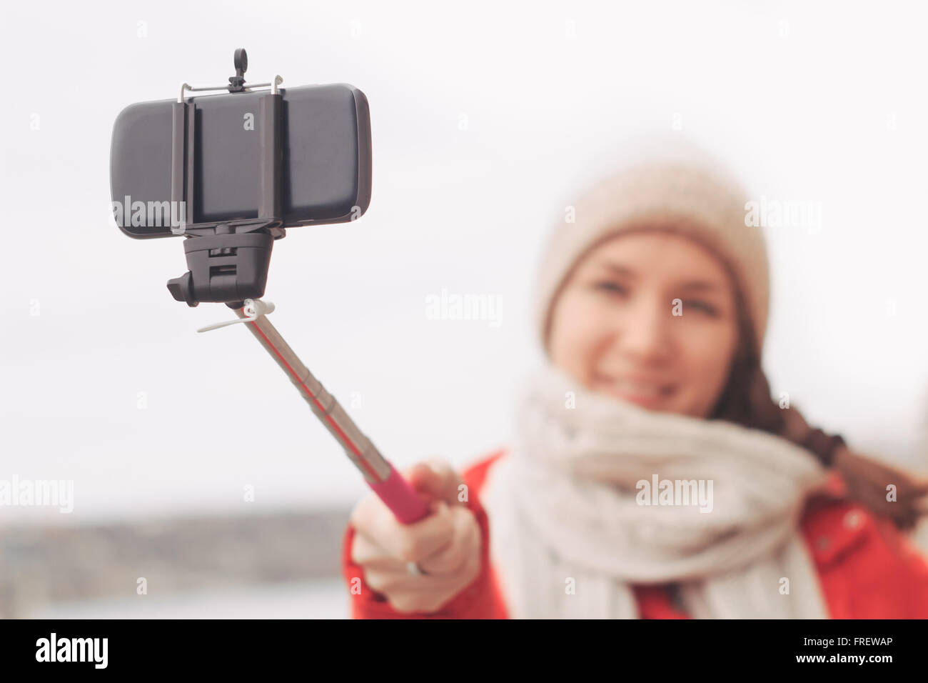 Young woman taking photo with selfie stick Stock Photo - Alamy