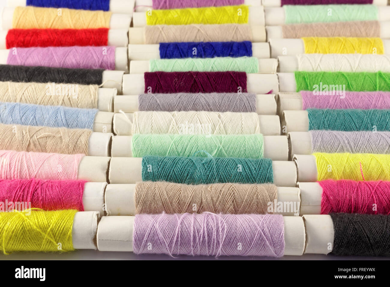 Multicolored bobbins of thread on white Stock Photo - Alamy