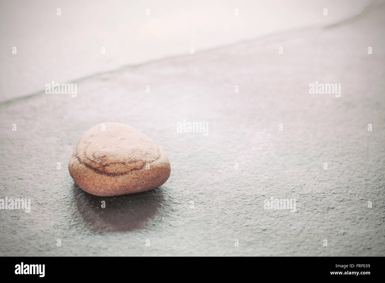 Retro toned stone on a slate, natural background with copy space ...