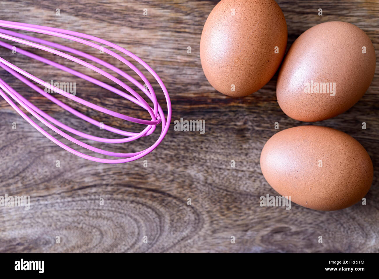 eggs and pink beater on wooden table Stock Photo - Alamy