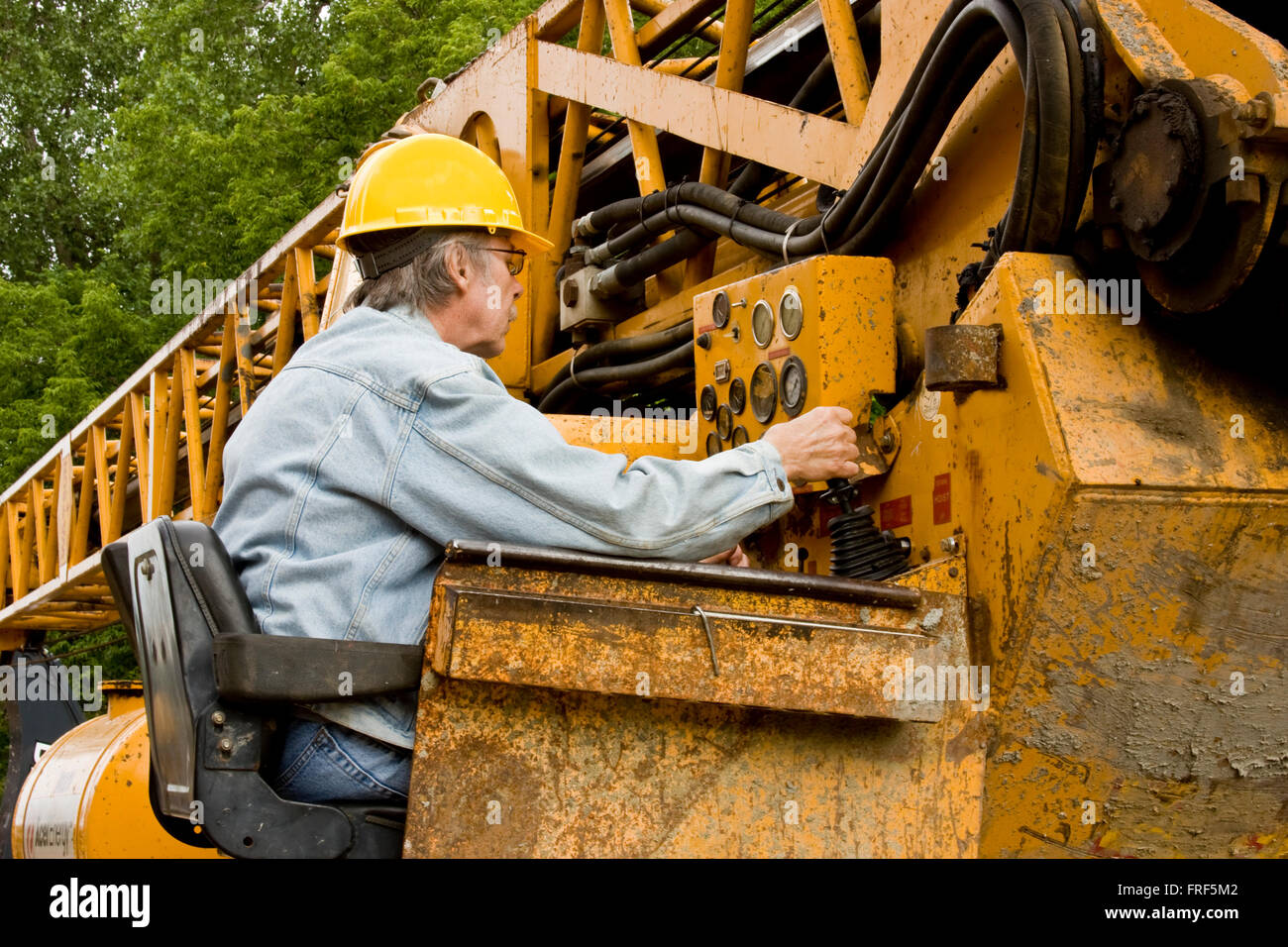 construction worker at the controls of a lifting crane Stock Photo - Alamy